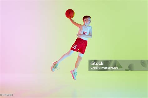 유니폼을 입은 봇 연습 중인 농구 선수 네온 불빛의 그라데이션 배경을 배경으로 한 손에 공을 들고 점프하는 역동적인 전신 이미지 10 11세에 대한 스톡 사진 및 기타