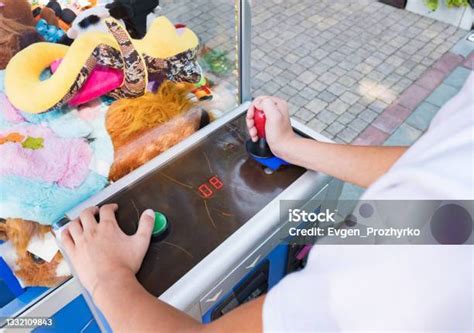 어린이의 손은 아케이드 크레인 자동 판매기의 빨간 조이스틱을 제어합니다 물건을 잡는 기계 장치에 대한 스톡 사진 및 기타 이미지 물건을 잡는 기계 장치 크레인 갈고리