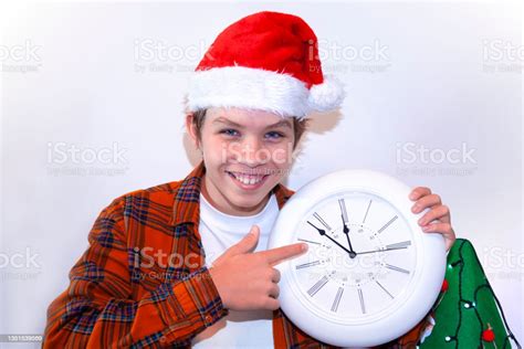 손에 크리스마스 선물을 들고 산타 빨간 모자에 재미 미소 즐거운 아이 소년과 빨간색 배경 에 선물 뒤에 숨어 놀라움에 대한 스톡