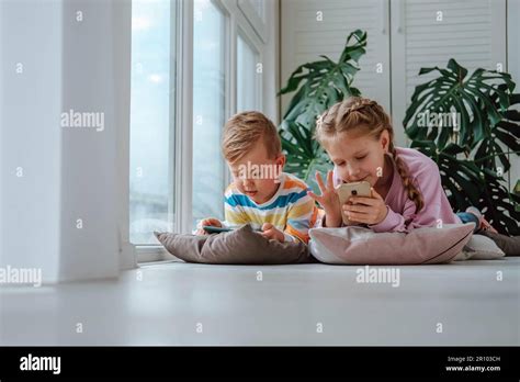 Kinder Liegen Auf Dem Boden Des Fensters Und Sehen Cartoons Auf Ihren Handys Bruder Und