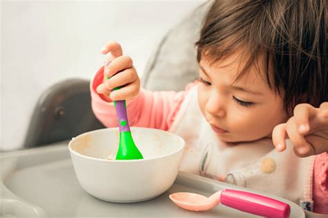 아기 유아용 의자에 숟가락으로 음식을 먹으려고하는 아이 의자에 먹는 훈련 건강한 생활방식에 대한 스톡 사진 및 기타 이미지 건강한 생활방식 귀여운 긍정적인 감정 표현
