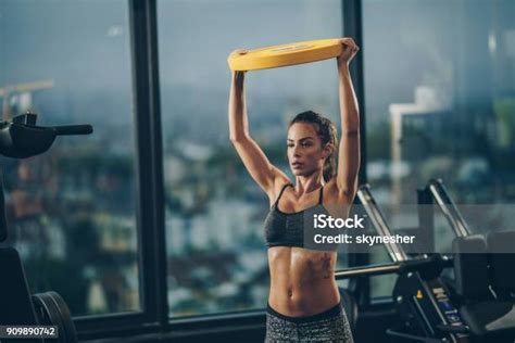 근육 구축 여자 체중 디스크와 함께 운동 하는 동안 체육관에서 교차 훈련을 데 근육질 체격에 대한 스톡 사진 및 기타 이미지 근육질 체격 여자 한 명의 여자만