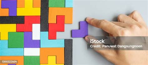 화려한 나무 퍼즐 조각과 기하학적 모양 블록을 연결하는 손 논리적 사고 비즈니스 논리 수수께끼 결정 솔루션 합리적 사명 성공 목표 및 전략 개념 감정에 대한 스톡 사진 및