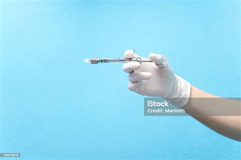 치과 마취 주사기 흰색 라텍스 장갑을 가진 젊은 여성의 손 니트릴 장갑 주사기를 들고 파란색 배경에 손에 대한 스톡 사진 및 기타 이미지 Istock
