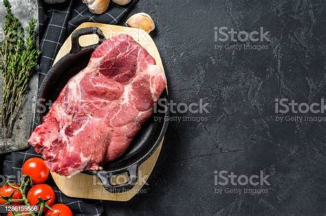 팬에 생 돼지 고기 커틀릿 스테이크 채소와 향신료로 준비 할 준비가 된 생 고기 조각 검은 색 배경 맨 위 보기입니다 복사 공간