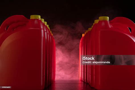 터널을 형성하는 빨간색 플라스틱 모터 오일 병의 두 기둥 어두운 배경에 라벨이 없는 손잡이와 노란색 나사 캡이 있는 용기의 전면 모습 0명에 대한 스톡 사진 및 기타 이미지