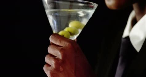 Androgynous Man Drinking Cocktail Against Black Background Stock Footage