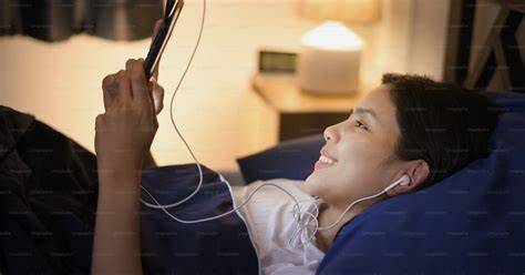 젊은 여성이 태블릿을 사용하여 침실에서 친구나 가족에게 영화 또는 화상 통화를 하고 있습니다 사진 Unsplash의 보고 이미지