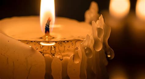 Close Up Of Melting Candle With Dripping Wax And Burning Flame In Warm