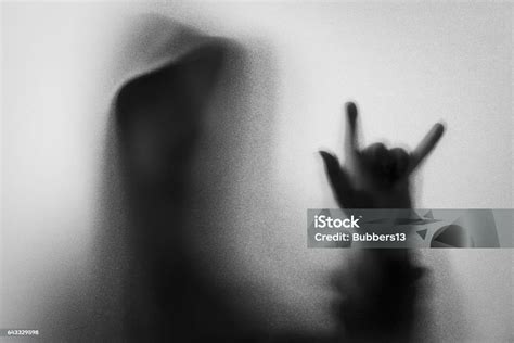 공포와 후드 자 켓 남자의 그림자 부분 손은 유리에 사랑 상징으로 할 젖 빛된 유리 뒤에 위험한 남자입니다 미스터리 남자입니다 할로윈 배경입니다 흑인과 백인 사진입니다