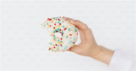 방에 흰 벽의 배경에 물린 맛있는 도넛을 들고 있습니다 생일 파티 축하 뿌리가있는 화려한 도넛 다이어트와 건강에 해로운 음식 사진 Unsplash의 음식 이미지