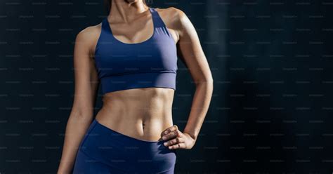 피트니스 클럽에서 운동하는 스포츠웨어를 입은 아시아 스포츠 소녀를 닫습니다 매력적인 운동 선수 젊은 여성 스탠드는 체육관 경기장이나 피트니스에서 기계와 장비로 운동을 마친