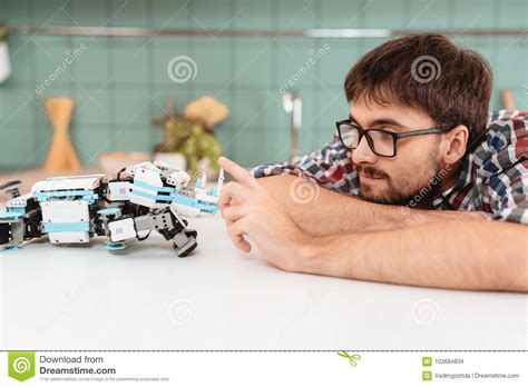 A Guy Posing With A Robot In A Modern Light Kitchen He Touched The