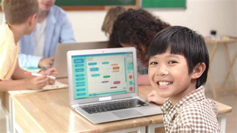 Skilled Asian Boy Coding Program And Looking At Camera In Stem Class