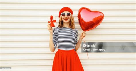 흰색 배경에 베레모와 치마를 입은 빨간 하트 모양의 풍선과 선물 상자를 가진 행복한 미소 짓는 여자의 초상화 25 29세에 대한 스톡 사진 및 기타 이미지 Istock