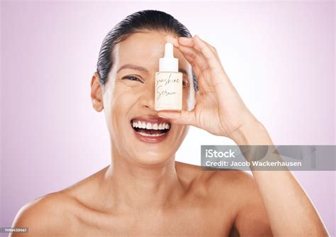 웃고 얼굴과 보라색 배경에 고립된 스튜디오에서 혈청병을 든 여자 스킨케어 화장품 초상화 히알루론산 레티놀 또는 에센셜 오일을