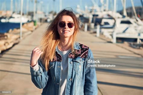 둥근 선글라스와 데님 재킷에 백인 아름다운 행복한 소녀 항구에서 여름 날 야외에서 긴 금발 머리 귀여운에 대한 스톡 사진 및 기타 이미지 Istock