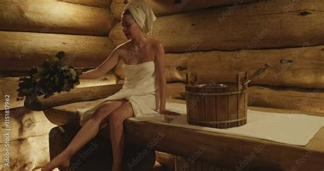 Woman Relaxing And Sweating In Russian Bath House In Towel Girl In Spa