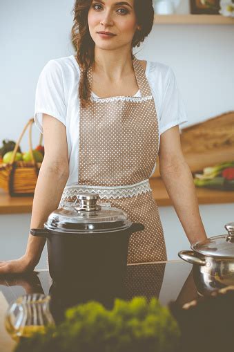 부엌에서 수프를 요리 하는 젊은 갈색 머리 여자입니다 그녀의 손에 나무 숟가락을 들고 주부 식품 및 건강 개념 가정 주방에 대한 스톡 사진 및 기타 이미지 Istock