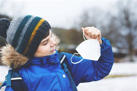 학교에 가는 길에 Ffp 의료 마스크를 착용한 아이 소년 어린이 배낭 가방 따뜻한 옷을 입고 추운 가을이나 겨울 날에 학교 키드 코로나 전염병 중 잠금 및 검역 시간