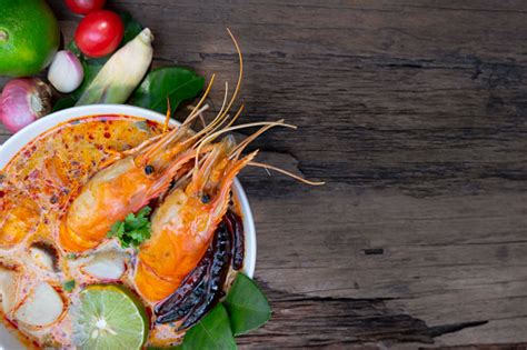 새우 수프 또는 톰 얌은 흰 접시에 태국에서 현지 음식 칠리 레몬 생강 갈 랑 알 레몬 그라스 오래 된 나무 배경에서 레몬 잎으로 구성 0명에 대한 스톡 사진 및 기타