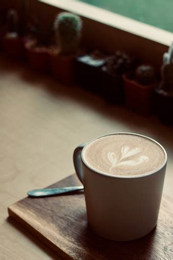 나무 테이블에 커피 아트가있는 Cofffe Latte 세라믹 컵 텍스트 또는 배경 사용을위한 빈 복사 공간 수직 샷 사진으로 선인장 블러 0명에 대한 스톡 사진 및 기타