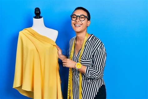 Beautiful Hispanic Woman With Short Hair Standing By Manikin Sewing