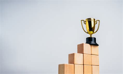 나무 큐브 위에 골드 트로피 막대 그래프 차트 단계 와 복사 공간 와 와 비즈니스 목표 및 성공 성취 경쟁 리더십 우승자 기회