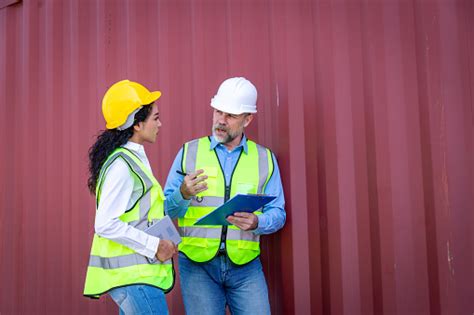건설 컨테이너 부두에서 일하는 엔지니어는 노트북 프로그램에서 컨테이너 데이터를 확인하고 검사하는 것은 컨테이너 운송 물류 사업 개념입니다 2명에 대한 스톡 사진 및 기타