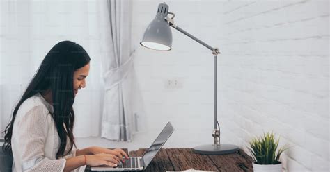 아시아 소녀는 집에 앉아있는 노트북 컴퓨터에서 집에서 일하고 전화를 받고 메모를 작성합니다 사진 Unsplash의 동료 이미지