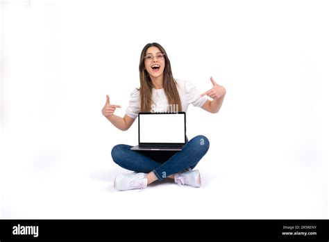 Teen Girl Sitting On The Ground And Showing Laptop Cross Legged Posing On Isolated White