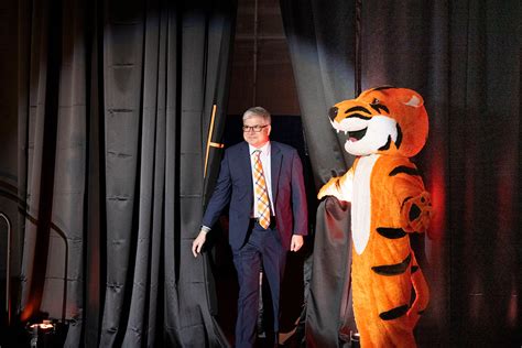 William Sanders Appears Walking Out From Behind A Black Curtain With The Rit Mascot Ritchie