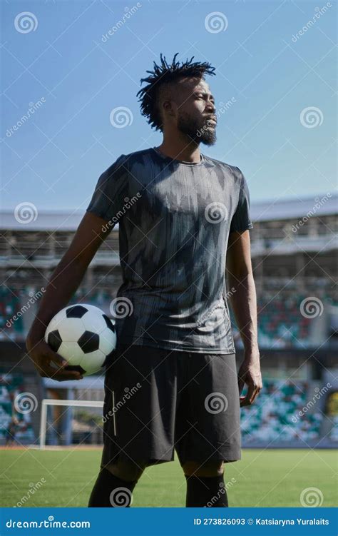 Intense Portrait Of A Football Player Holding The Ball In The Stadium