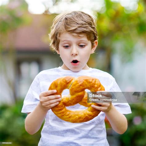 사랑스러운 작은 아이 소년 먹는 거대한 큰 바이에른 독일어 프레첼 행복 금발의 아이 를 즐기는 맛있는 Tratditional 빵 행복한 아이들을 위한 건강한 음식 가족에