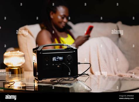 Woman Sits With Battery Energy Bank That Provides Lighting And Emergency Backup When The Power