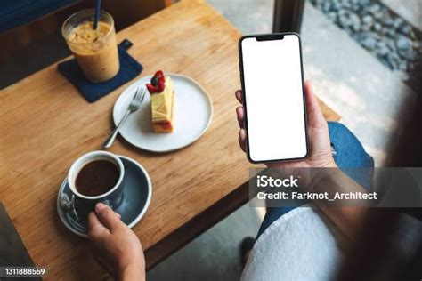 카페에서 커피를 마시면서 빈 흰색 데스크톱 화면으로 휴대 전화를 들고있는 여성 30 34세에 대한 스톡 사진 및 기타 이미지 30 34세 공란 레스토랑 Istock