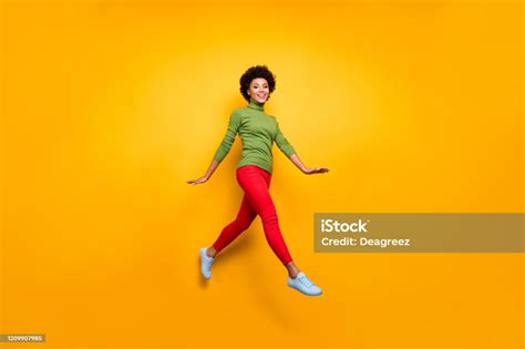전체 길이 몸 크기 는 빨간 바지 흰색 신발 고립 된 선명한 색상 배경에서 점프를 실행 곱슬 물결 갈색 머리 소녀의 사진을 돌렸다 갈색 머리에 대한 스톡 사진 및 기타