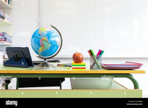 Detail Of A School Classroom Teachers Table With Objects On It Tablet And Keyboard World