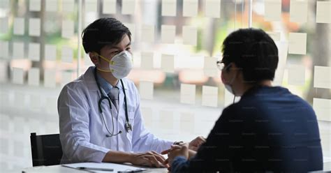 검사실을 배경으로 의사 작업 책상에 함께 앉아 있는 동안 젊은 환자 남자와 이야기토론하는 의사의 잘린 이미지 사진 Unsplash의 두 사람 이미지