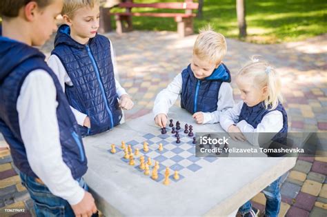 주제 어린이 학습 논리적 개발 마음과 수학 오산 전진 이동 합니다 큰 가족 형제와 여동생 백인 남자와 소녀는 체스 파크 밝은 맑은 날씨가을 재생 아이에 대한 스톡 사진 및