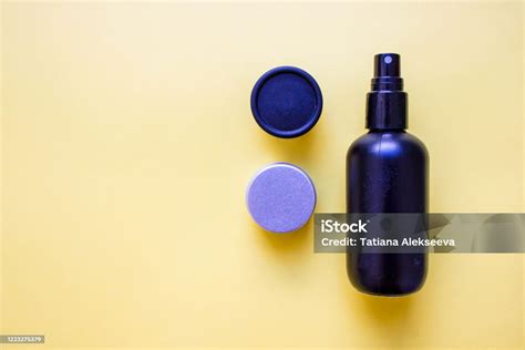재활용 플라스틱으로 만든 검은 색 플라스틱 용기는 노란색 배경의 화장품에 재사용됩니다 재활용의 개념과 친환경적인 사용 여유 복사 공간 맨 위 보기 0명에 대한 스톡 사진 및