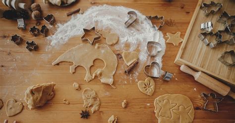 지저분한 테이블 상위 뷰에서 크리스마스 쿠키를 함께 만드는 가족 분위기 있는 휴가 시간 귀여운 딸과 어머니가 진저브레드 쿠키를 위해 반죽을 자르고 있다 진정성 있는