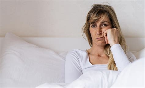 Усталая женщина сидящая в постели не может уснуть рано утром из за бессонницы европейская