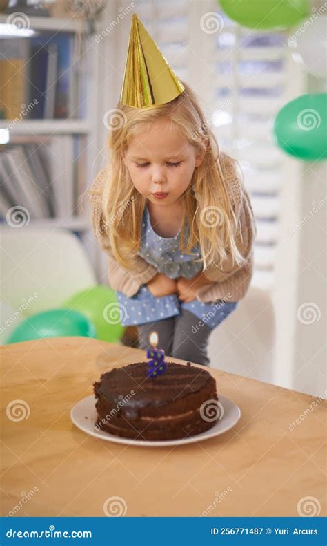 Blowing Out Her Birthday Candle A Young Girl Blowing Out The Candle On
