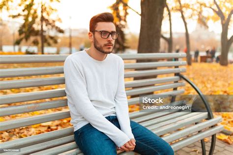 외로운 잘생긴 남자가 앉아 슬픈 공원 벤치에 가 시즌 노란색 바탕에 나뭇잎 외로움 개념입니다 학생이 시험을 통과 하지 않았다 나는 여자와 가을에 대한 스톡 사진 및 기타