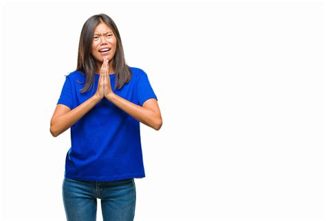 구걸 하 고 손으로 얼굴 매우 감정적이 고 걱정에 희망 식 함께 기도 격리 된 배경 위에 젊은 아시아 여자 용 서에 대 한 요구 종교 개념입니다 감정에 대한 스톡 사진 및