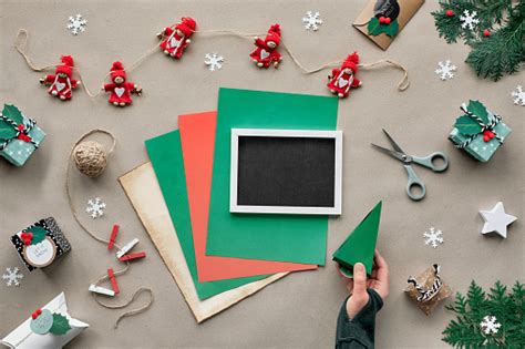 제로 폐기물 크리스마스 평면 평신도 섬유 장신구 화환 포장 된 선물 컬러 용지에 복사 공간이있는 칠판과 공예 종이 배경의 상단