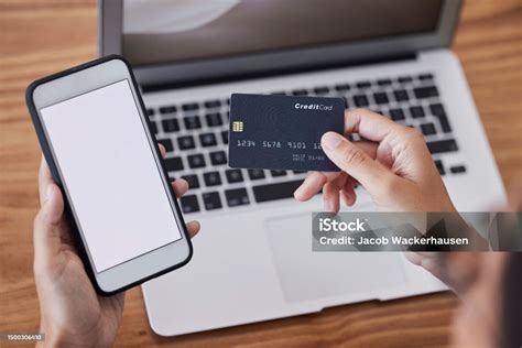 사무실 책상에서 전자 상거래 구매 또는 전자 거래를 위한 손 신용 카드 및 전화 모형 인터넷 뱅킹 앱 또는 온라인 쇼핑을 위한 모바일 스마트폰 디스플레이를 들고 있는