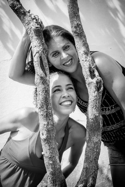 Premium Photo Portrait Of Two Girls Between A Tree Branch Against A Light Blue Wall