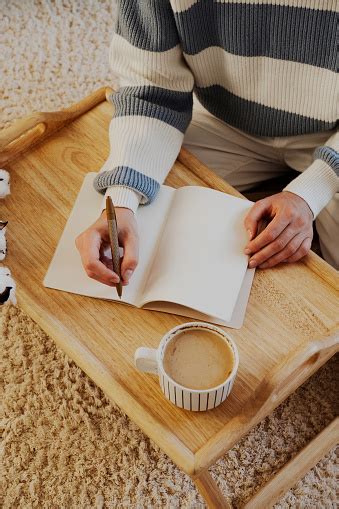 나무 쟁반에 커피 한 잔과 함께 공책에 글을 쓰는 사람 일기 쓰기 계획 아늑한 작업 공간 및 휴식의 테마에 이상적입니다 가을에 대한 스톡 사진 및 기타 이미지 Istock